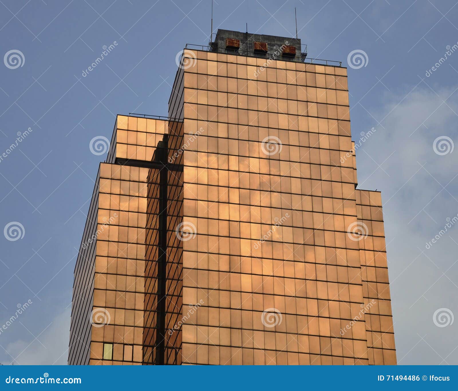 Golden Glass Building Soaring into Blue Sky Stock Photo - Image of ...