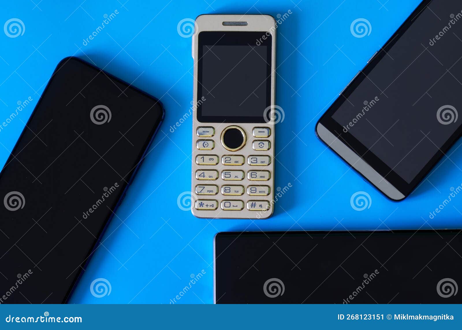 Golden Push-button Mobile Phone Compared To Smartphones of Different ...