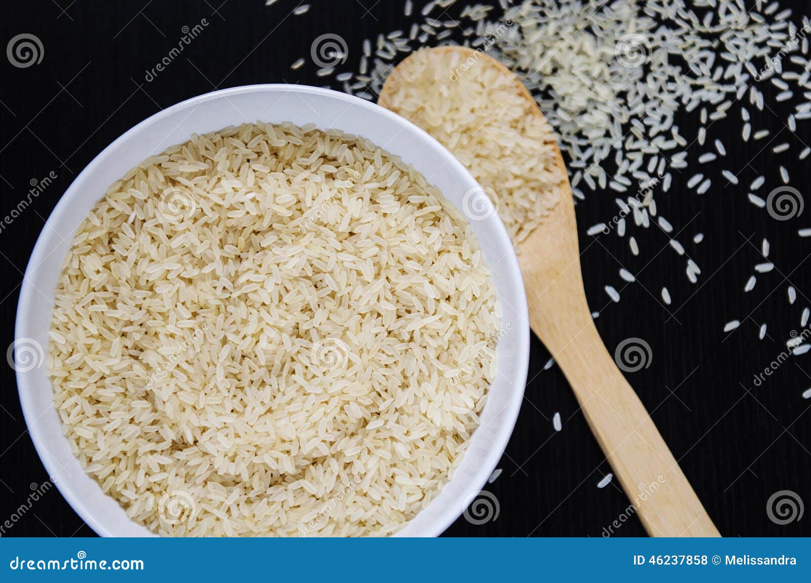 Golden Rice in a Bowl with Spoon on Dark Table Stock Photo - Image of ...
