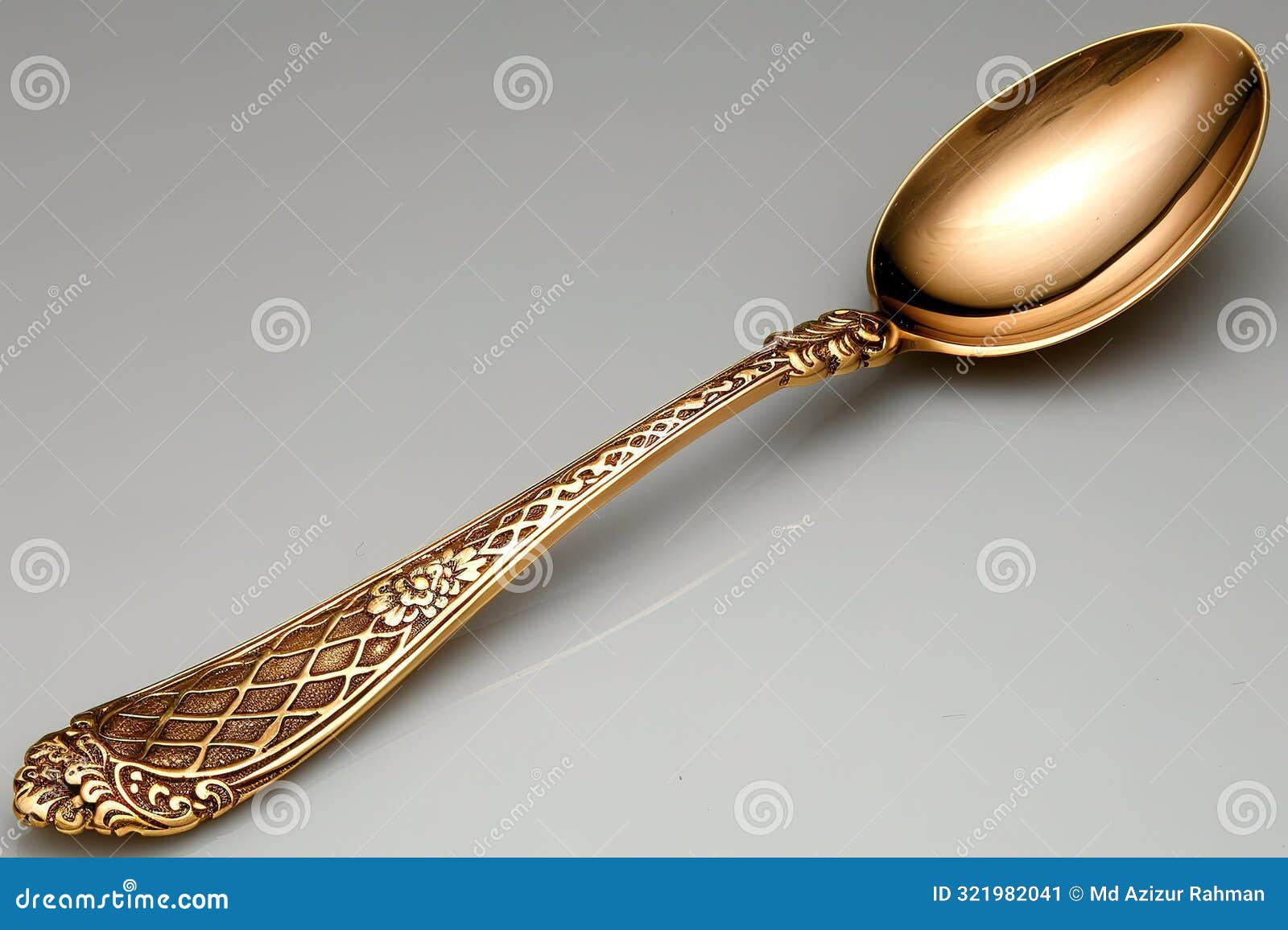 A Golden Spoon with a Handle, with a Simple Design and Shape on a White ...