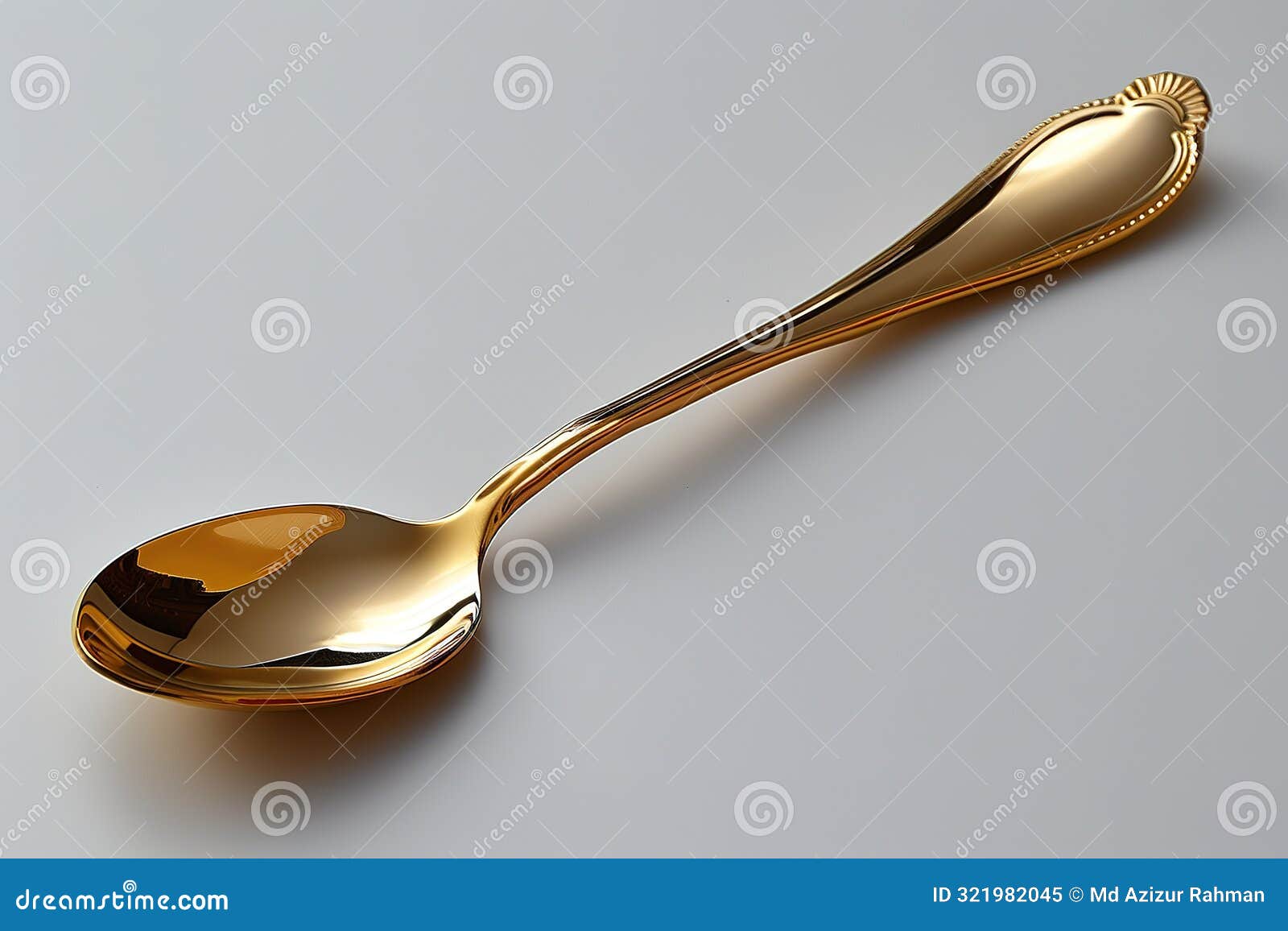 A Golden Spoon with a Handle, with a Simple Design and Shape on a White ...