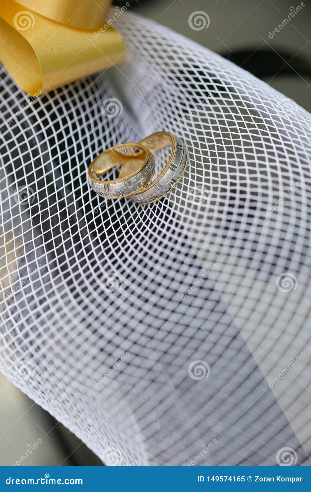 Golden Wedding Rings on the White Mesh with Yellow Ribbon Stock Image ...