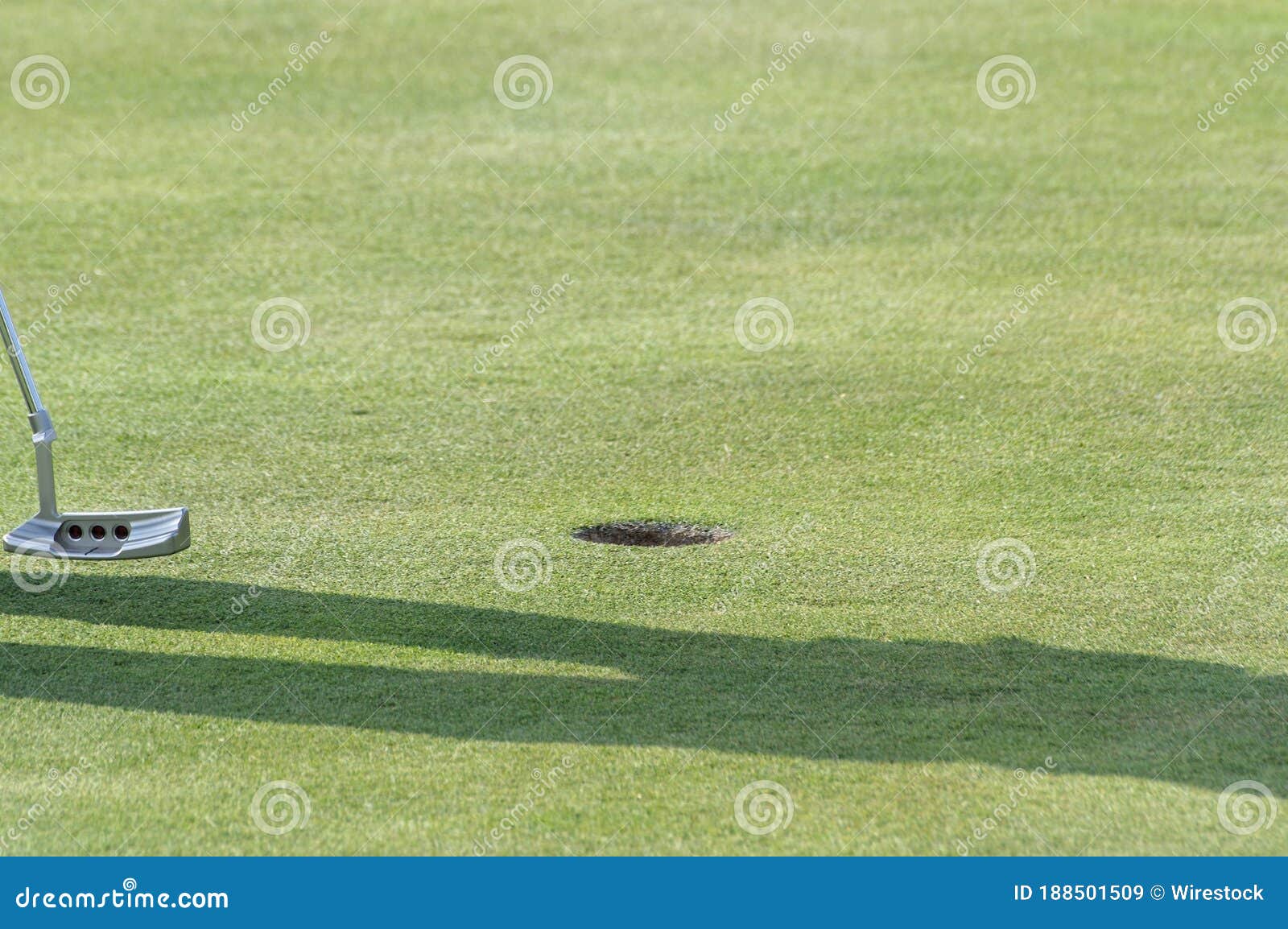Golf Club in Front of the Hole and the Shadow of a Person on the Grass ...
