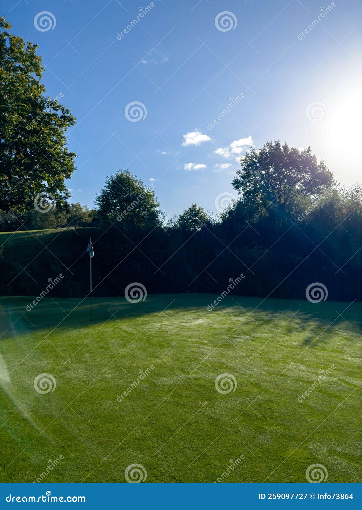 Golf Course Green with Blue Sky and Flag in View, Autumn Day with Dew ...