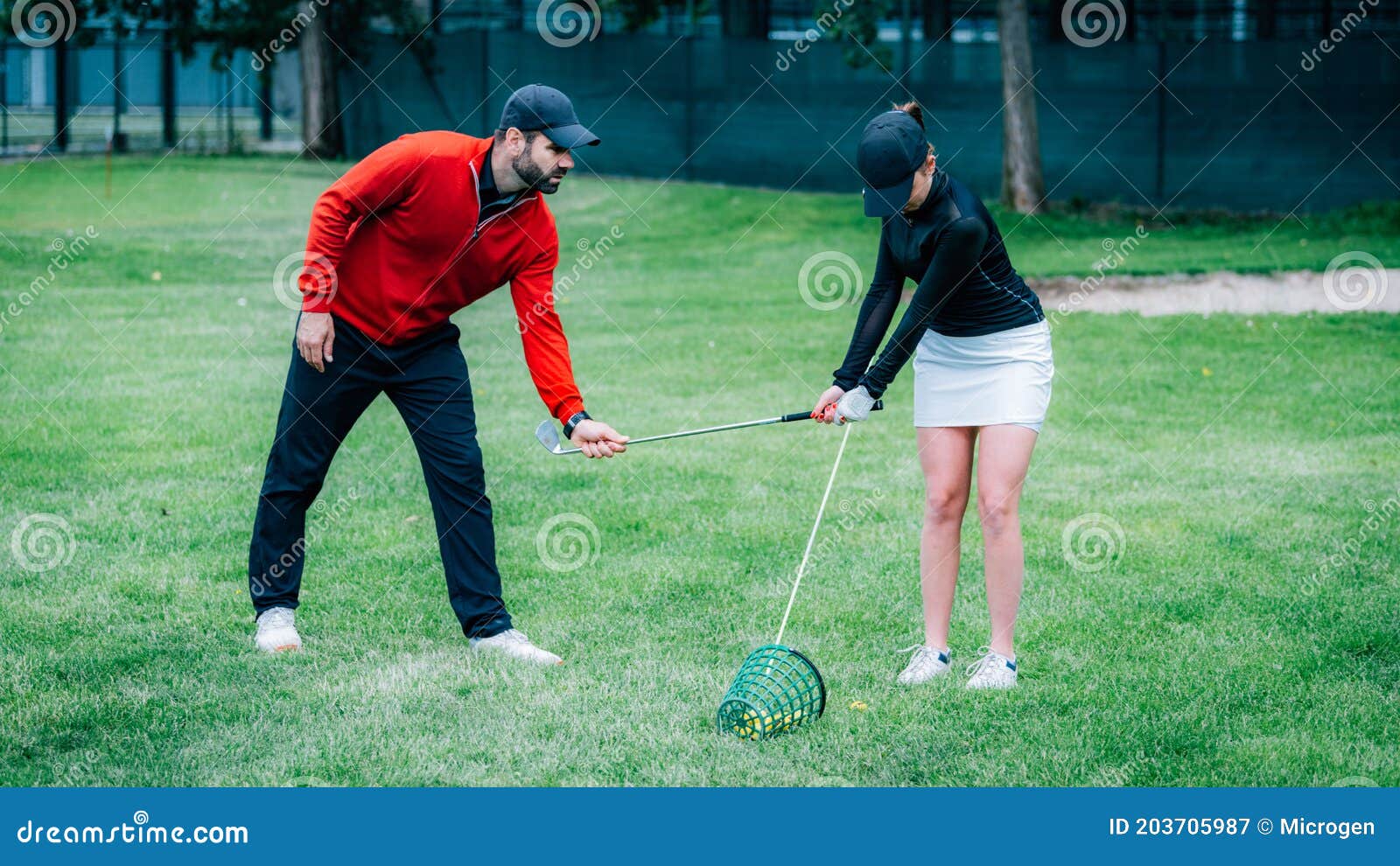 Golf Instructor Working with Young Woman on Swing Improvement Stock ...