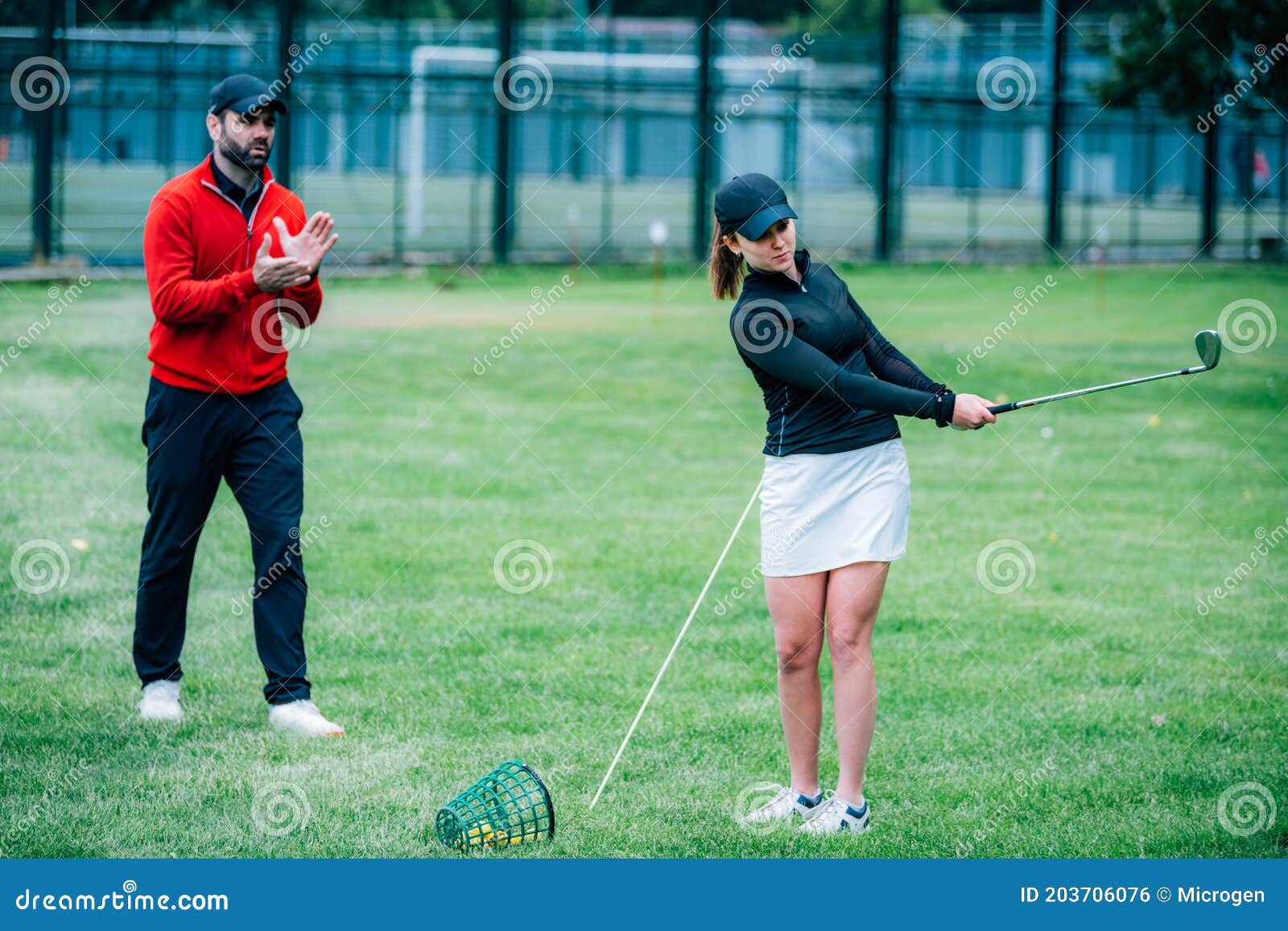 Golf Instructor Working with Young Woman on Swing Improvement Stock ...
