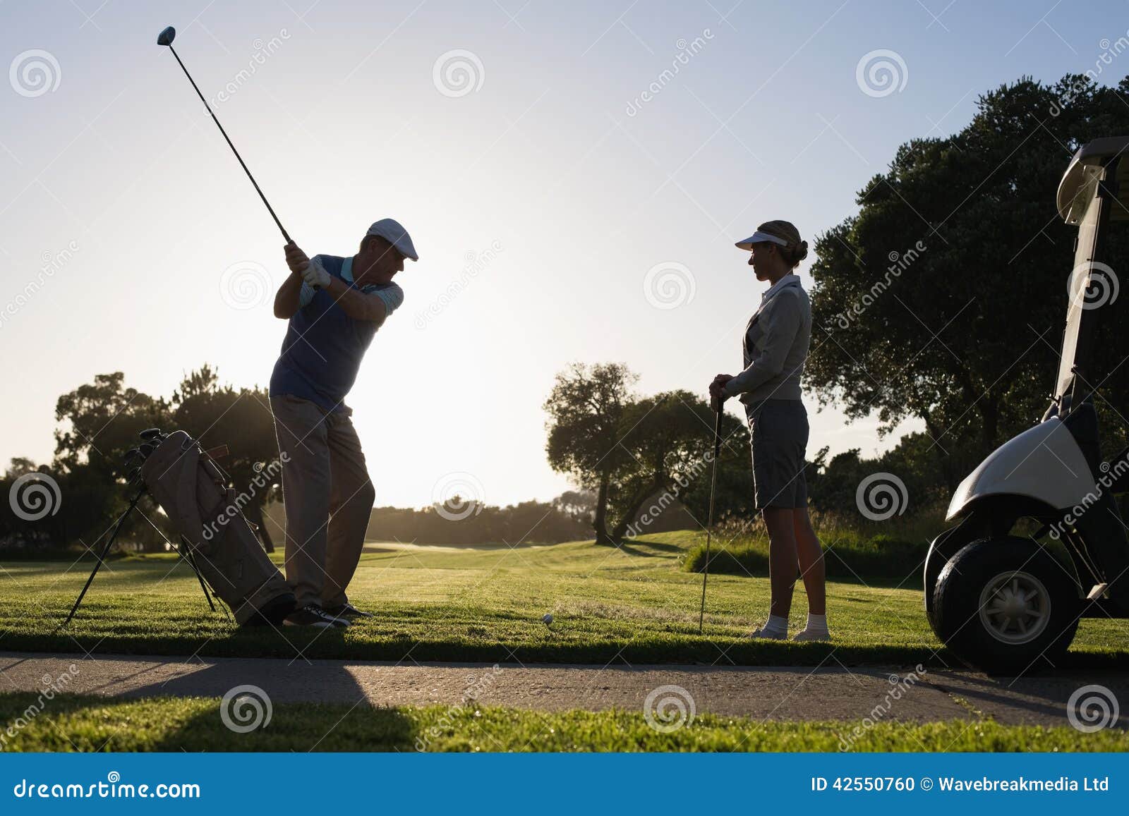 Golfing Couple Teeing Off for the Day Stock Photo - Image of full ...