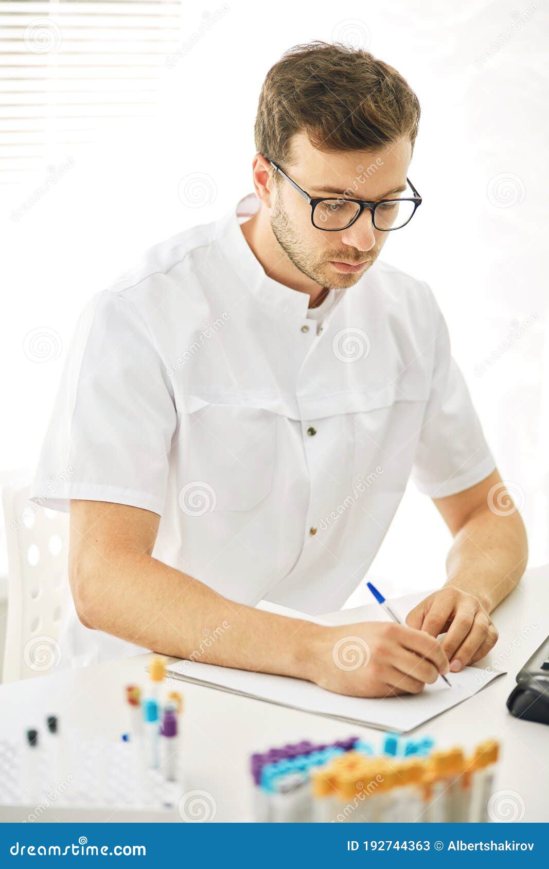 Good Looking Lab Technician in White Uniform Writing on Paper Stock ...