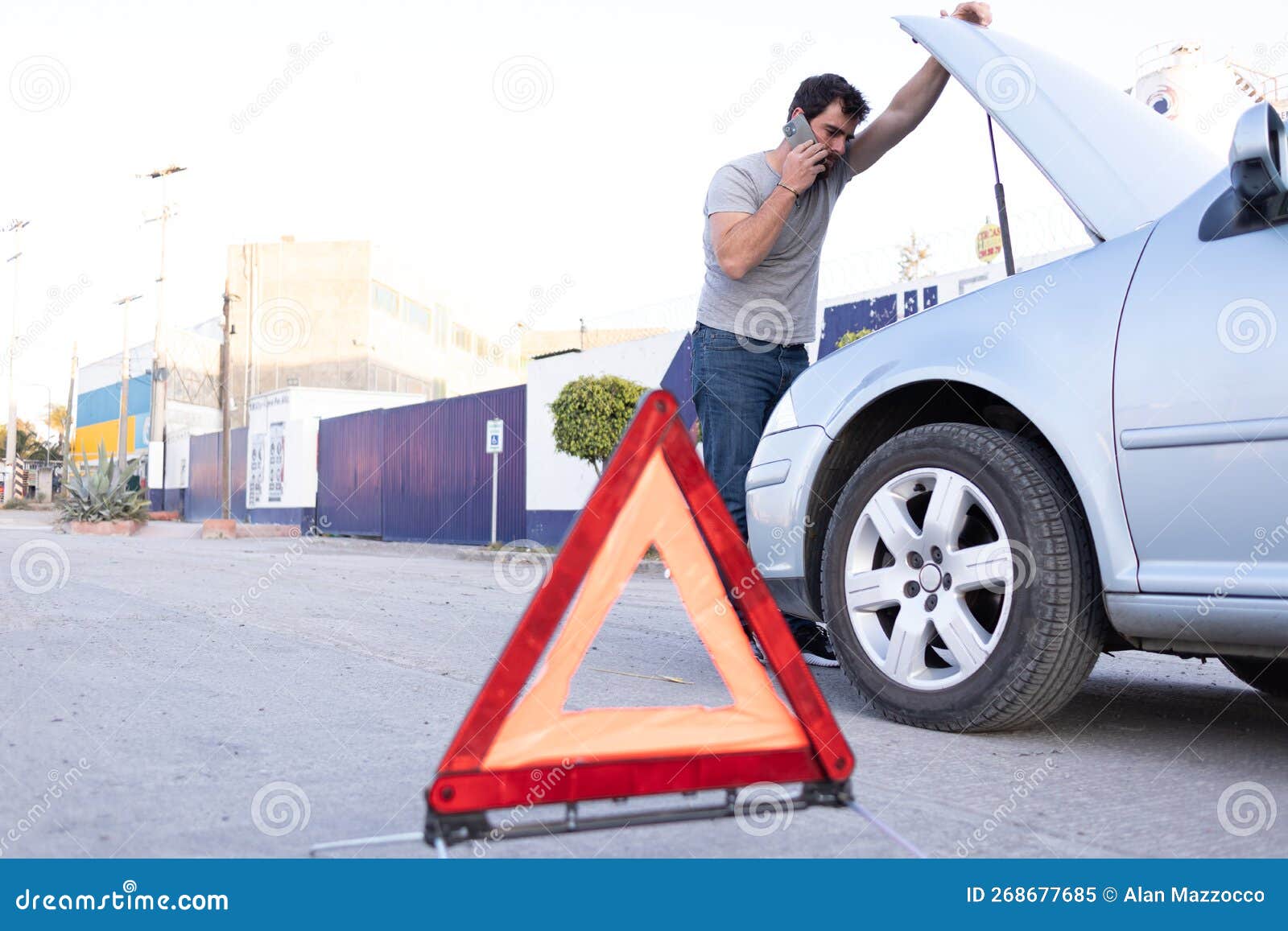 Young Man Checking at the Engine of a Car, Hazard Triangle on the Road ...