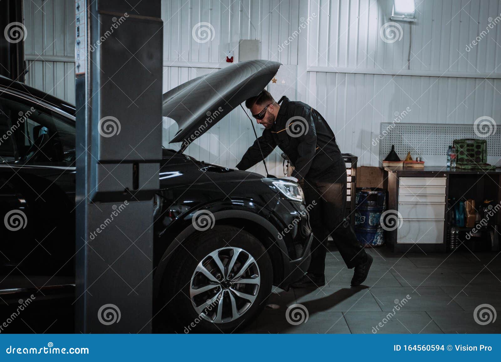 Good Looking Mechanic Guy Looking at the Car Engine in a Car Service ...