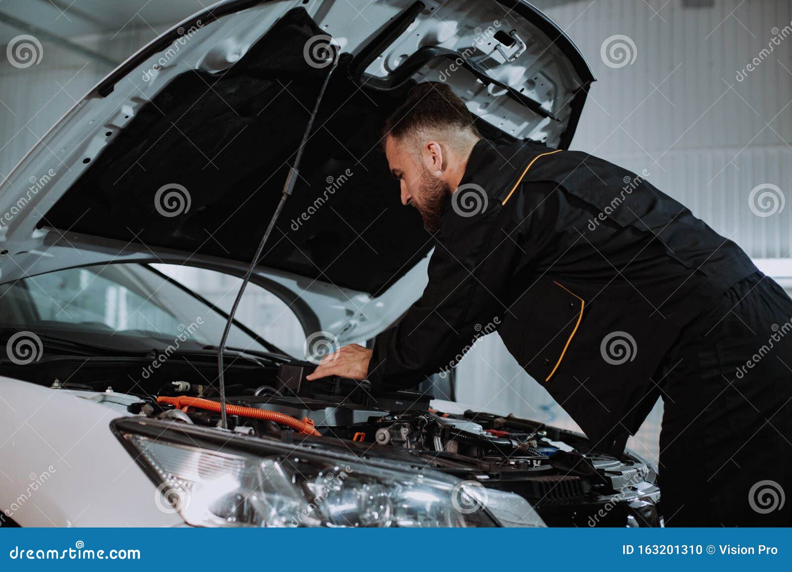 Good Looking Mechanic Guy Working on the Engine of the Car he Solve the ...