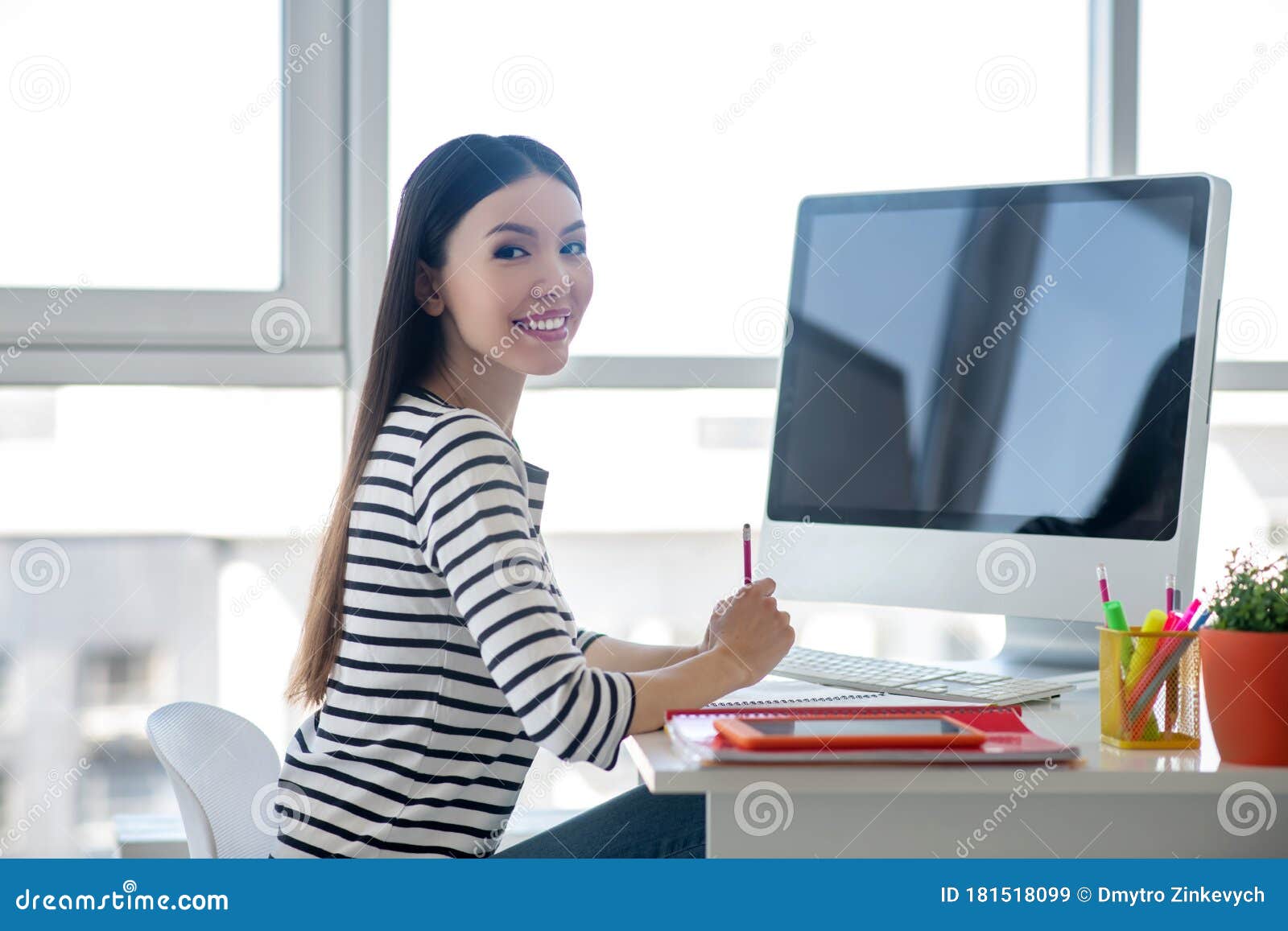 Dark Haired Pretty Woman In A Striped Shirt Smiling Nicely Stock Image