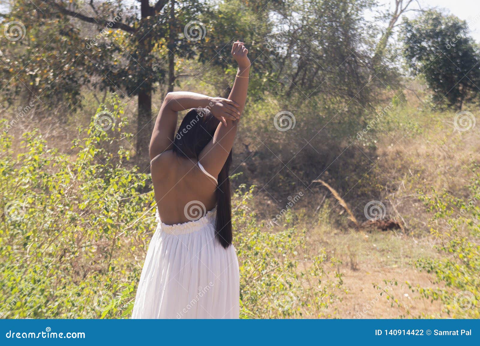 Backless Beautiful Bride Hands Over Head in Front of a Deer in the ...