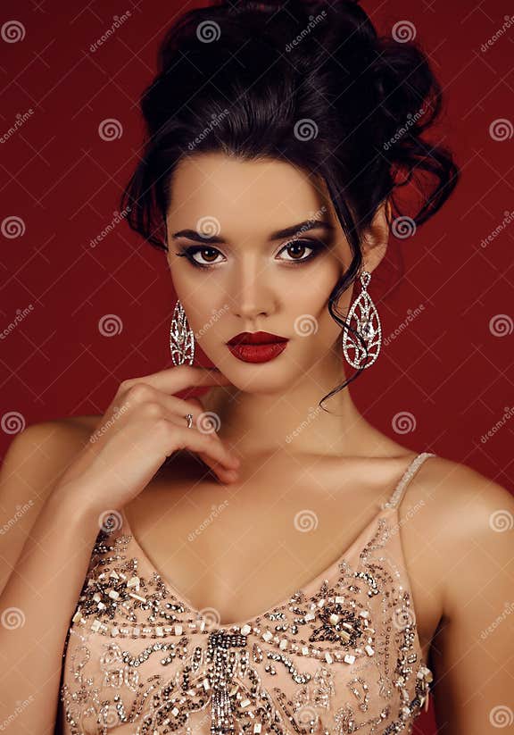 Gorgeous Woman With Dark Hair Wears Luxurious Sequin Dress And Bijou