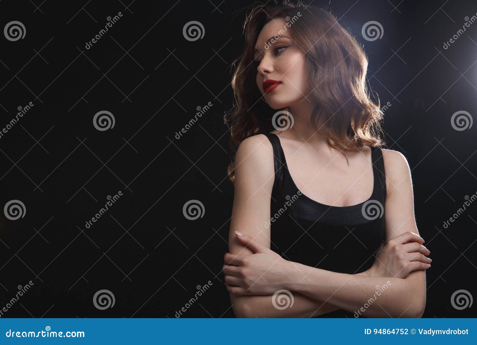 Gorgeous Young Woman Standing With Arms Crossed And Looking Away Stock