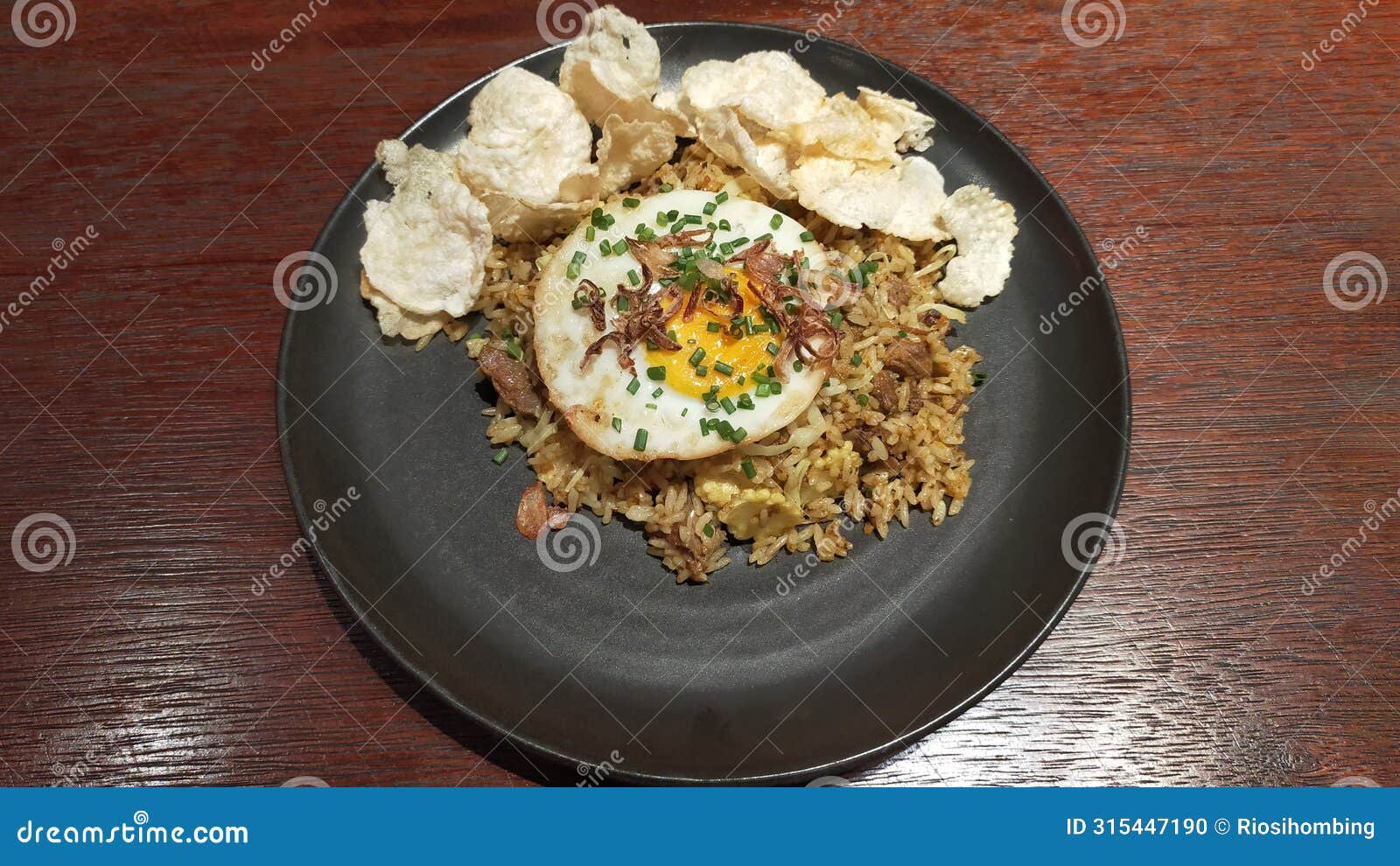 Gourmet Fried Rice with Sunny Side Up Egg and Crispy Toppings on Dark ...