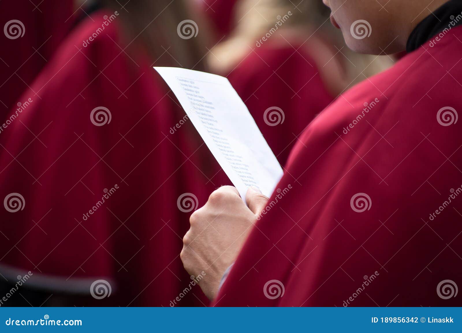 Graduate Student Nervously Reading a Piece of Paper in Hands or Singing ...
