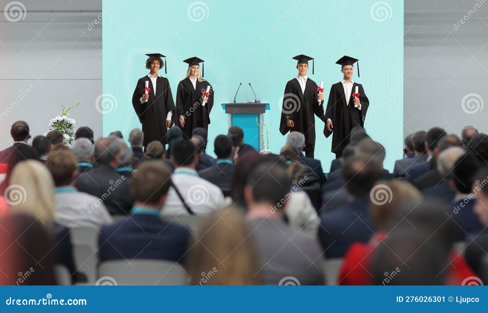Graduate Students Holding Certificates Standing on a Podium in Front of ...
