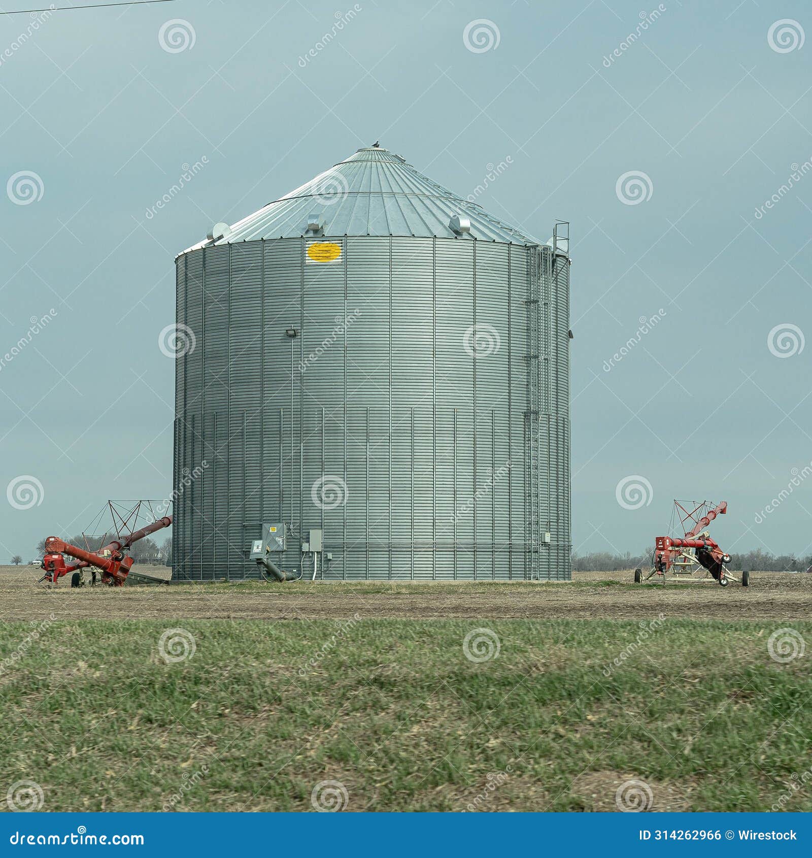 Grain Bin with Agricultural Equipment in the Field Stock Photo - Image ...