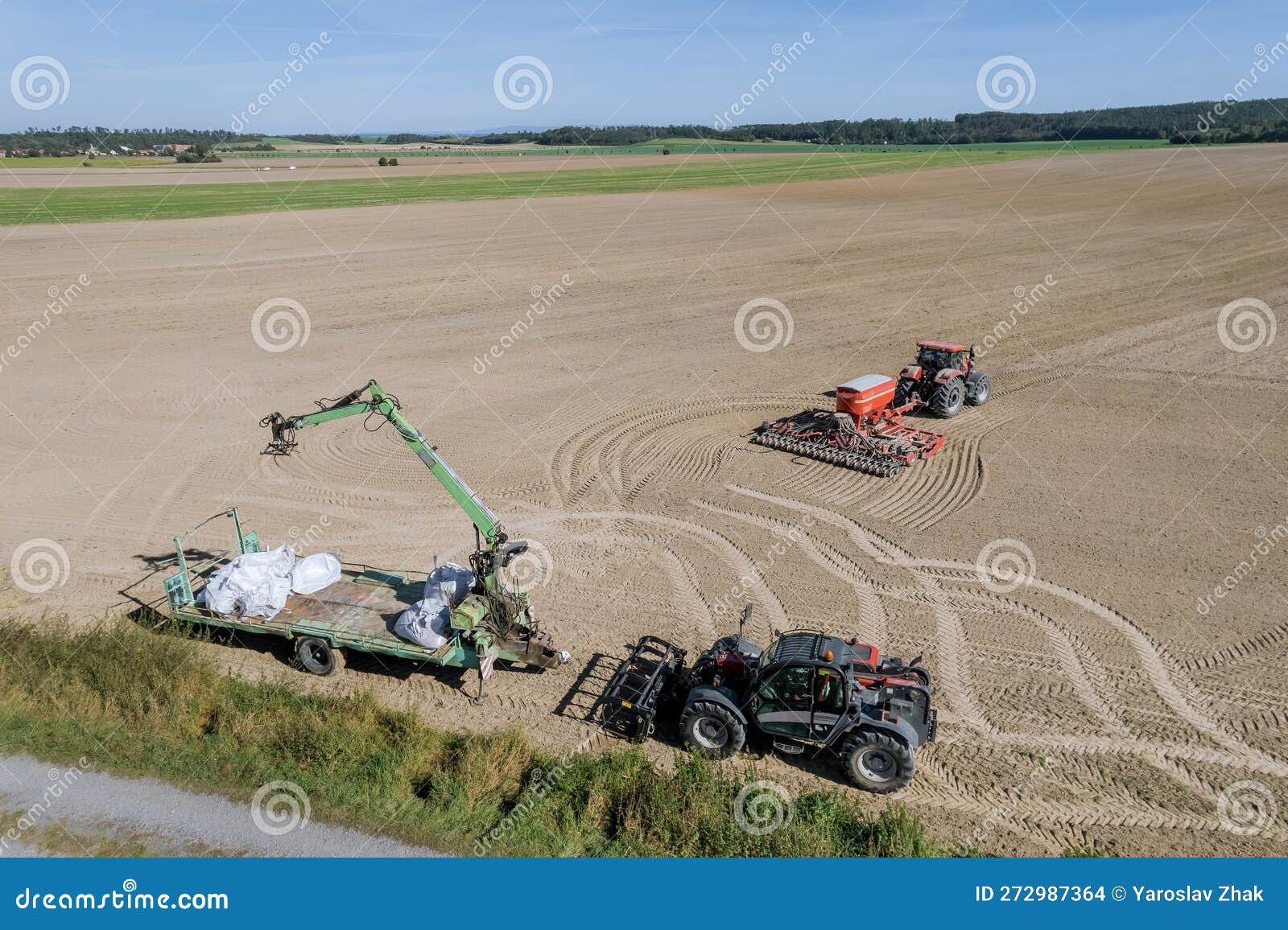 Grain Loader and Tractor with Seeder in the Field. Sowing Grain Using ...