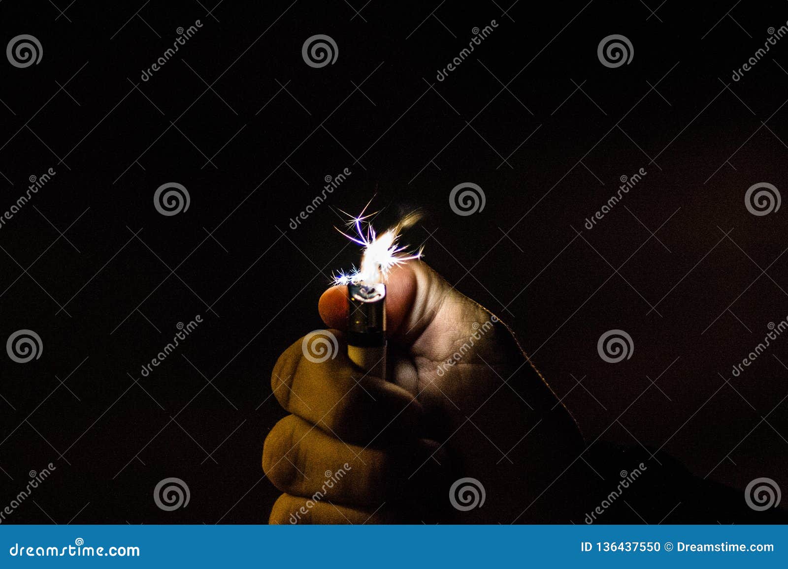 Grainy Image of a Hand Holding a Lighter in the Night Making a Spark ...