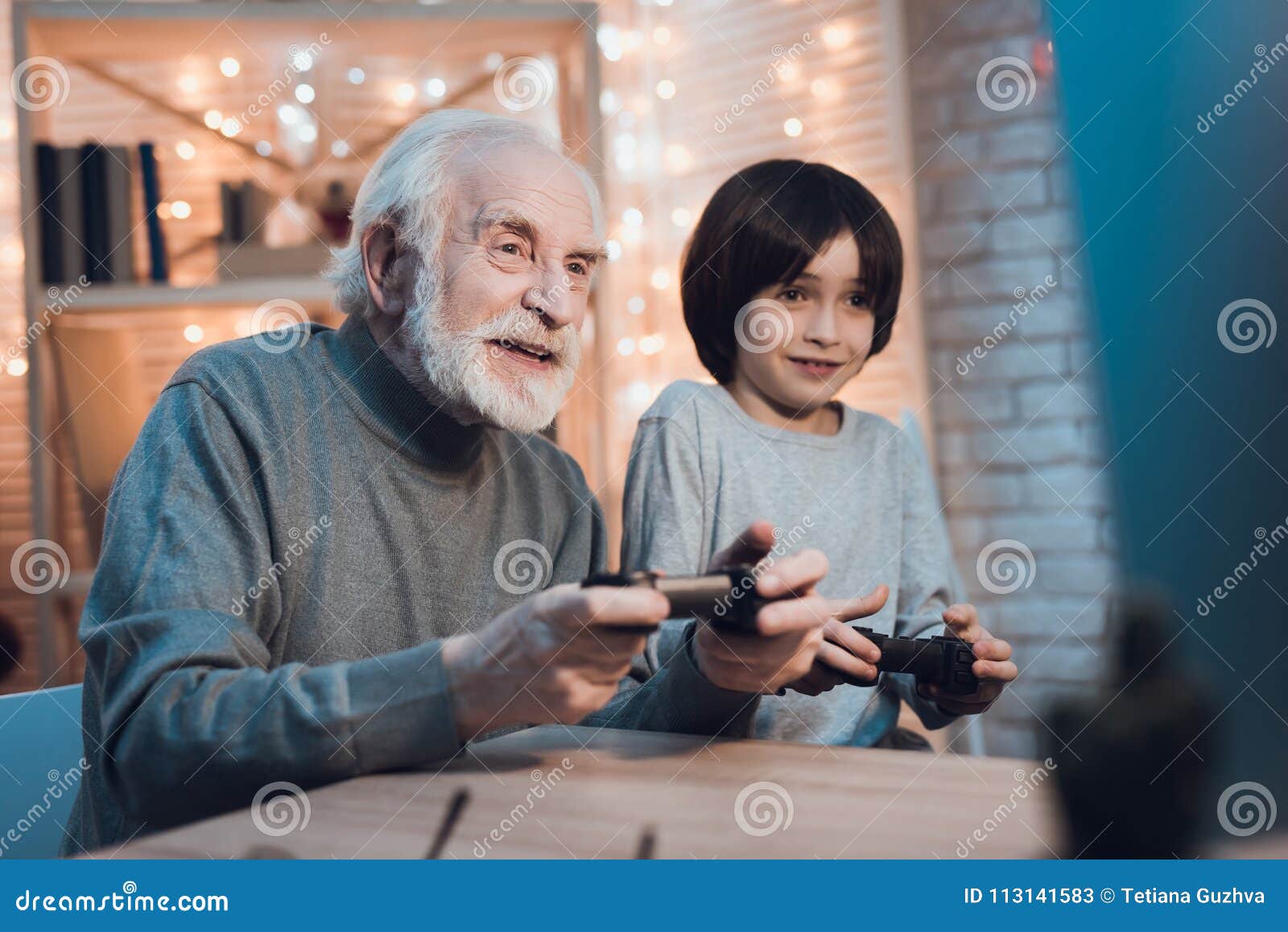 Grandfather and Grandson are Playing Video Games on Computer at Night ...