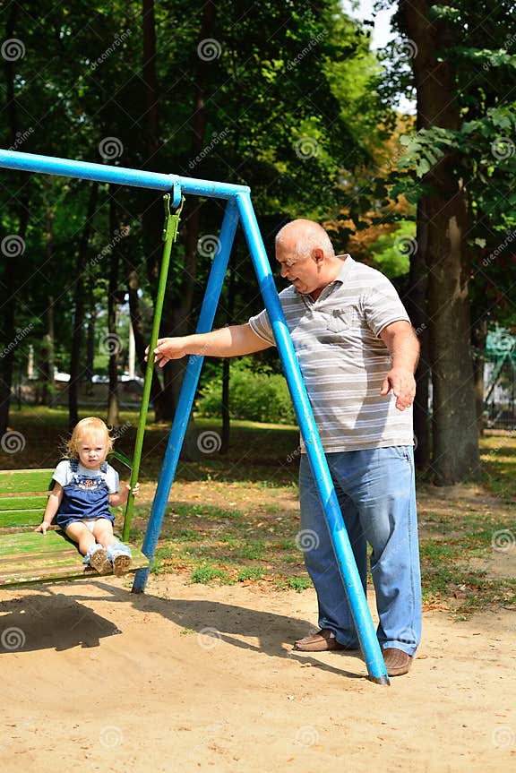 Grandfather Rides Granddaughter On A Swing Stock Image Image Of