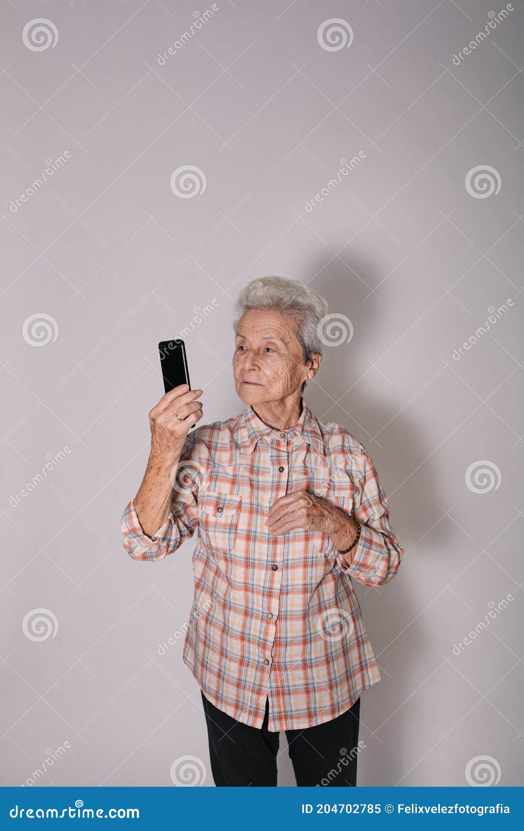 Grandmother Looking at a Smartphone. Making a Video Call. Vertical ...