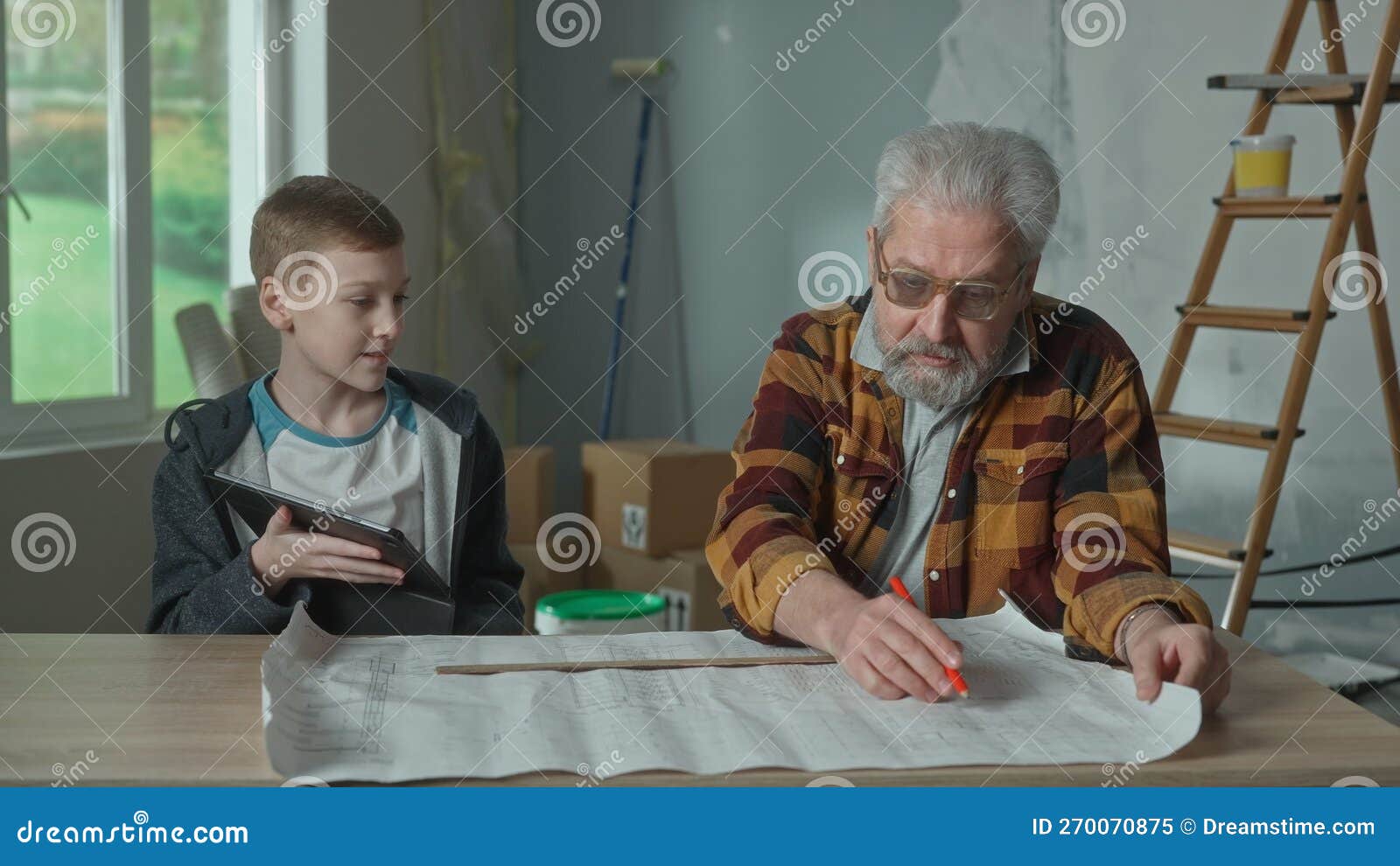 Grandpa is Planning Repairs and Making Notes on Project with Pencil and ...