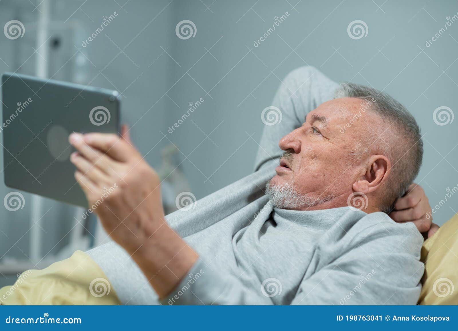 Grandpa Using an Electronic Tablet while in Bed Stock Image - Image of ...