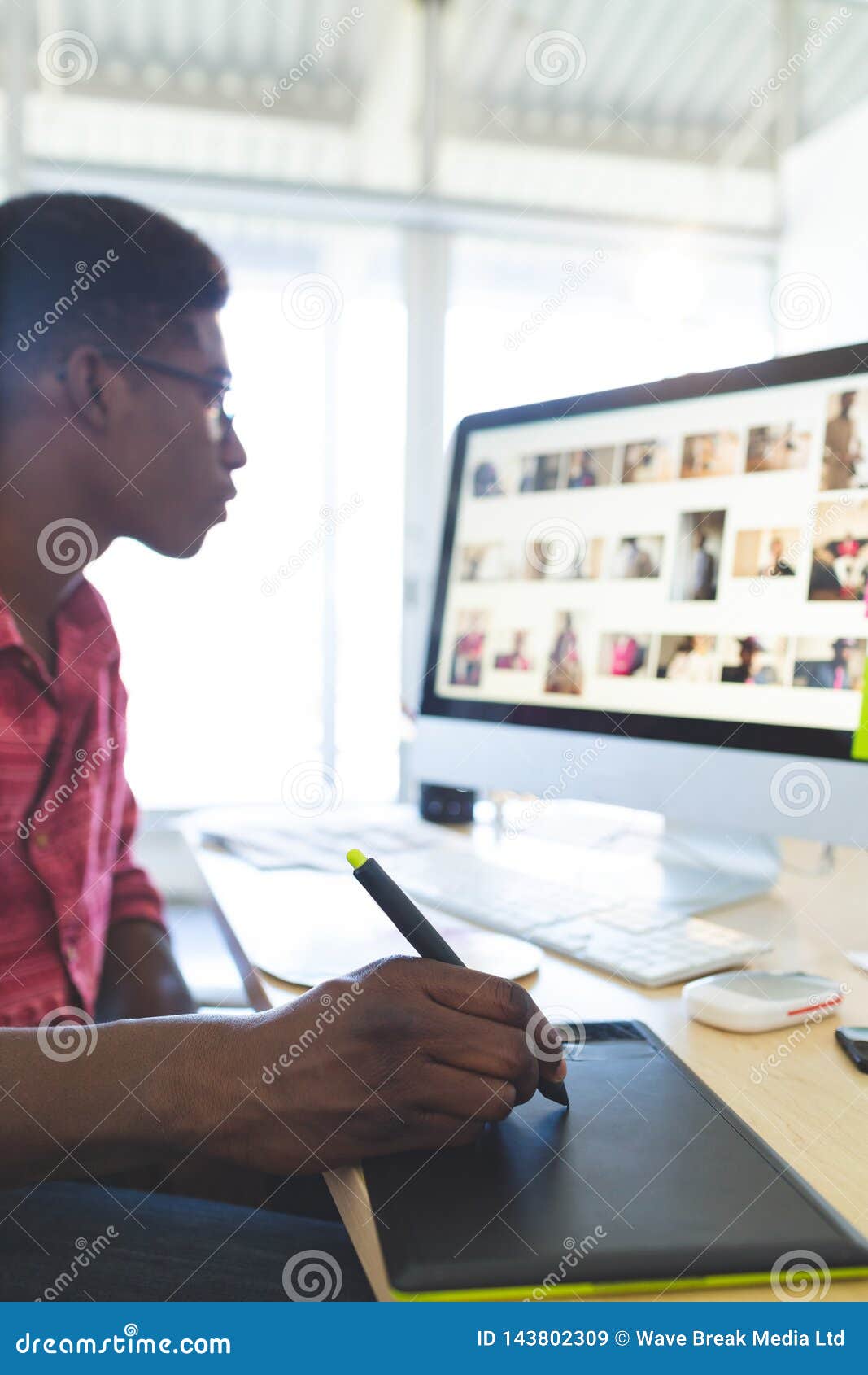 Graphic Designer Working on Graphic Tablet and Computer at Desk in ...