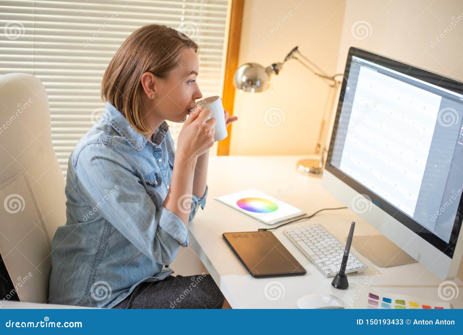 Graphic Designer Works on a Computer Using a Graphic Tablet on a Table ...