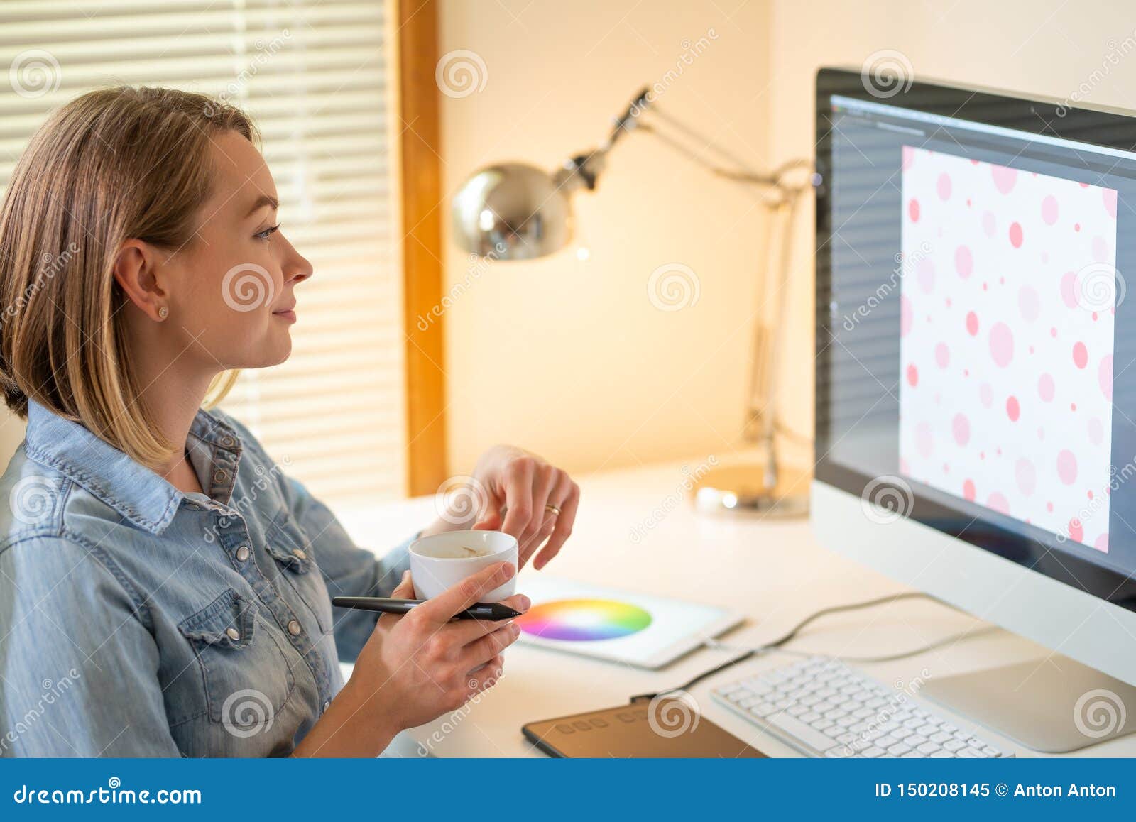 Graphic Designer Works on a Computer Using a Graphic Tablet on a Table ...