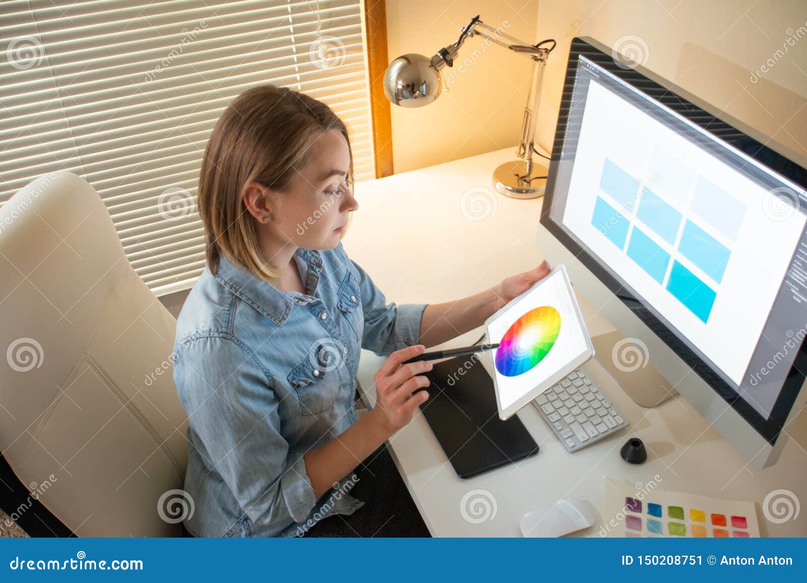 Graphic Designer Works on a Computer Using a Graphic Tablet on a Table ...