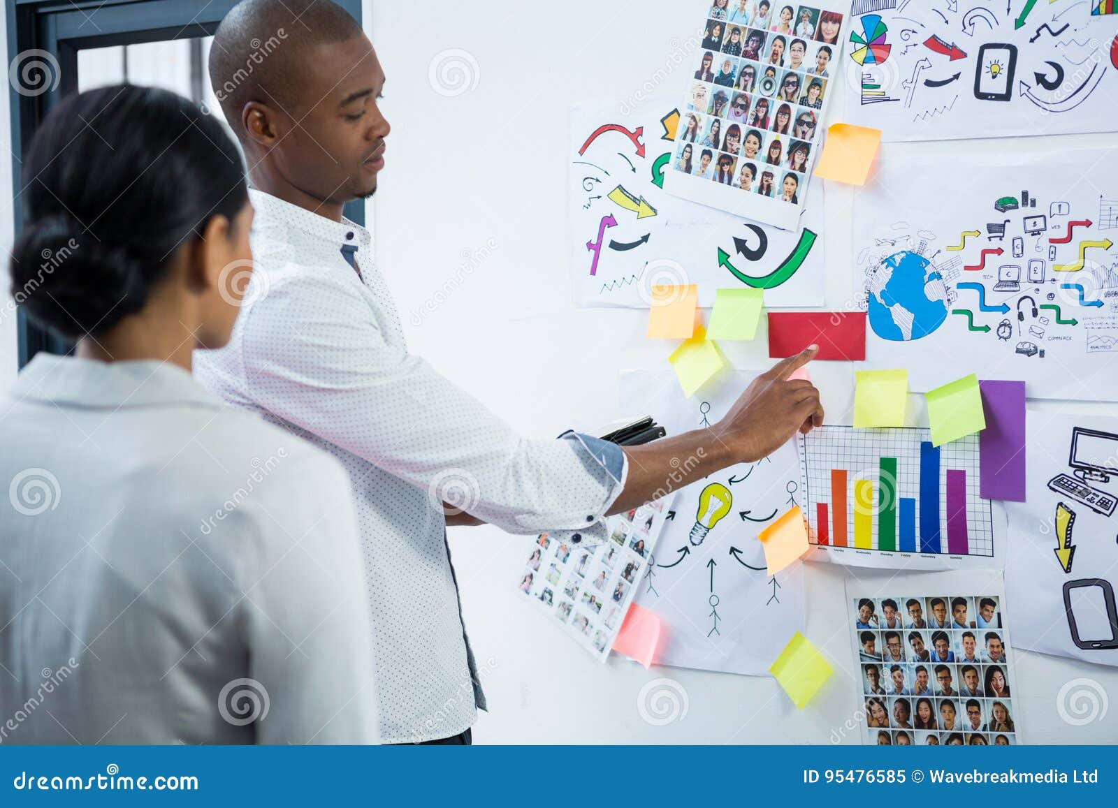 Graphic Designers Discussing Over Sticky Notes on Board Stock Image ...