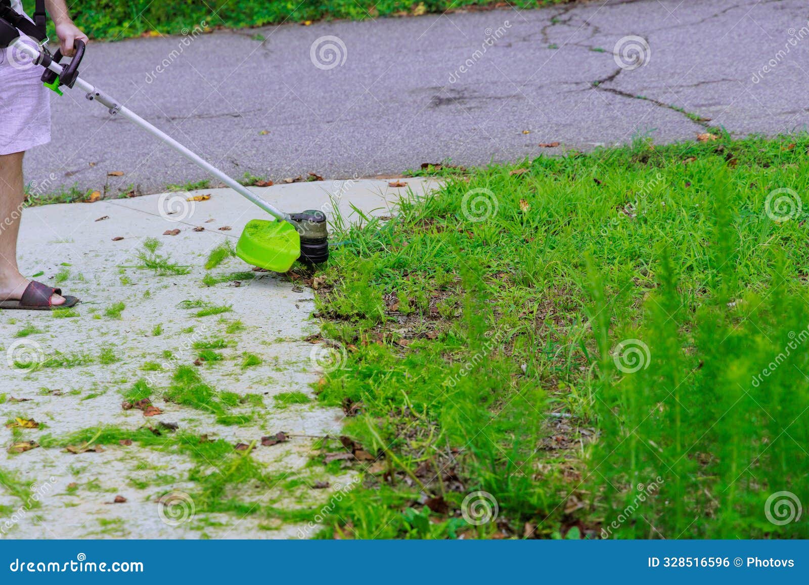 Grass is Mowed by Worker Using Hand Trimmer in a during Lawn Care Weed ...