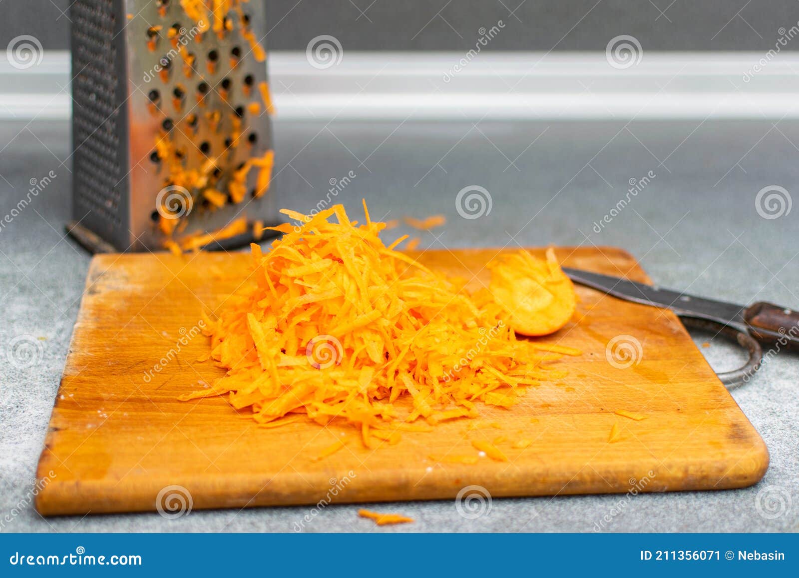 Grated Carrots on a Grater on a Cutting Board Stock Image - Image of ...