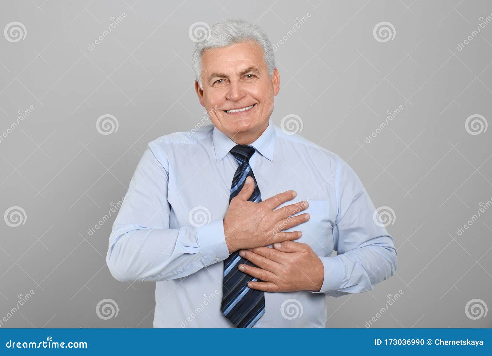 Grateful Senior Man with Hands on Chest Against Light Grey Background ...