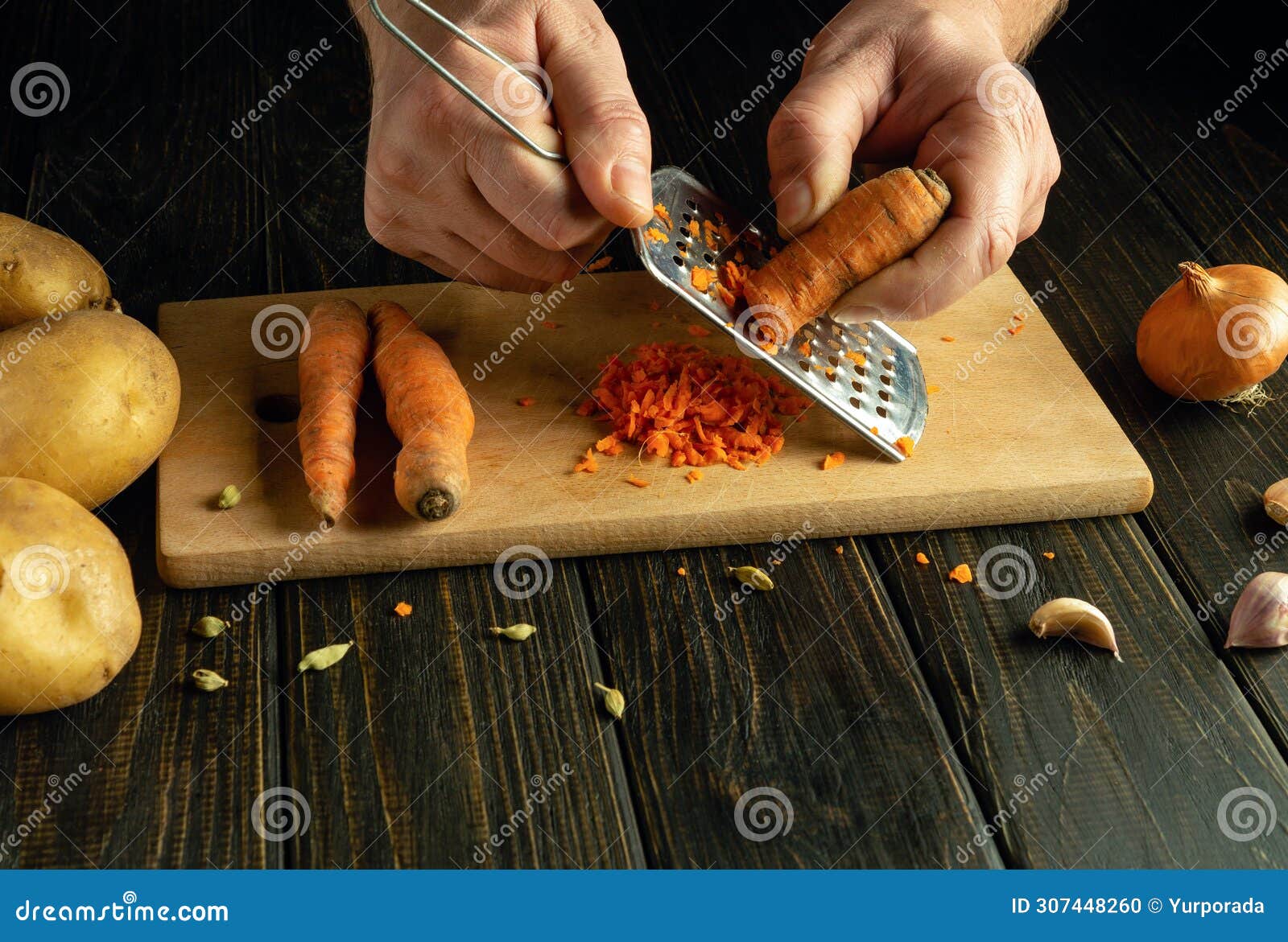 Grating Carrots with a Grater on a Kitchen Board. Chef Hands Preparing ...