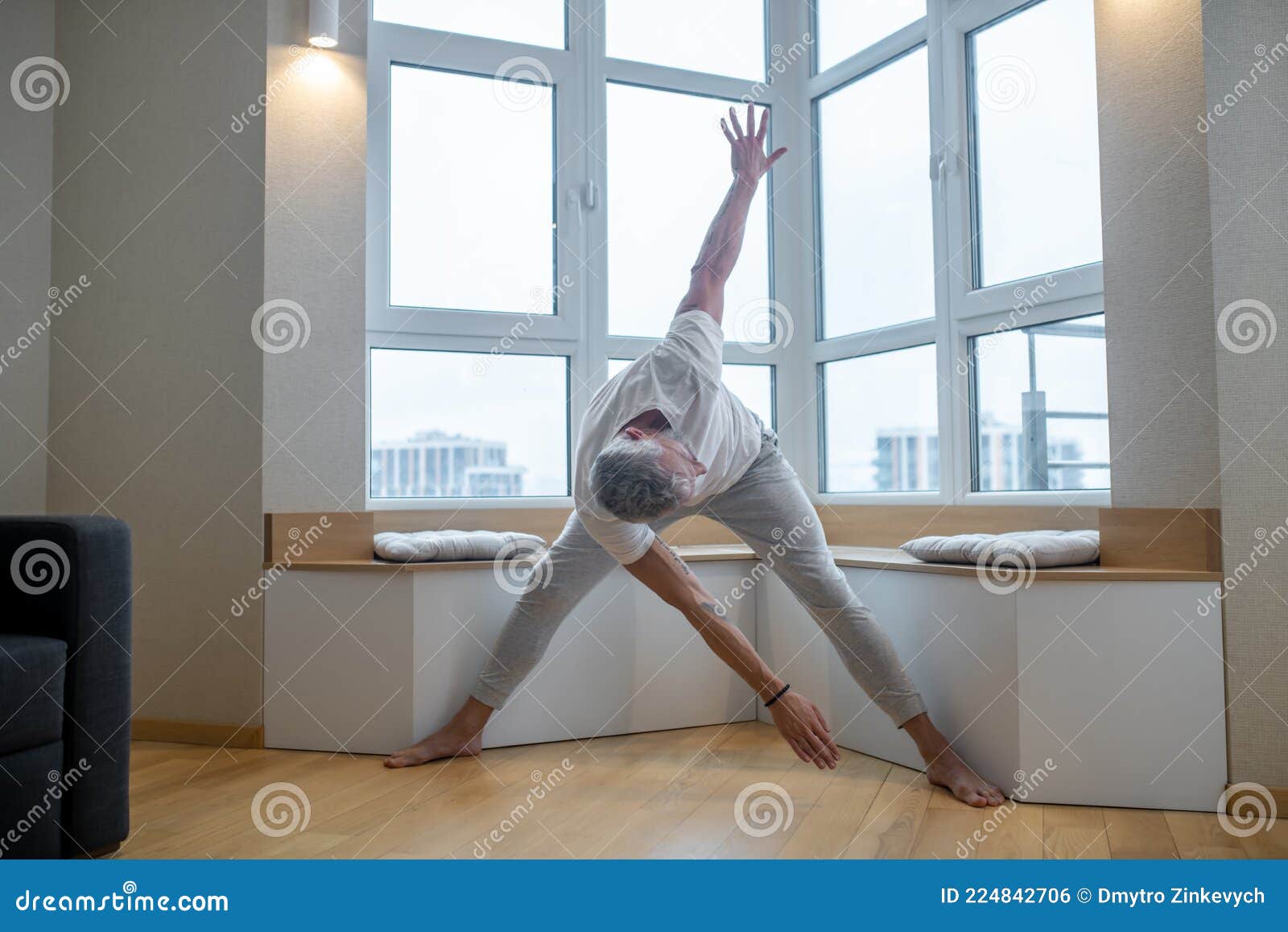 Gray-haired Man in a White Tshirt Standing in a Triangle Pose Stock ...