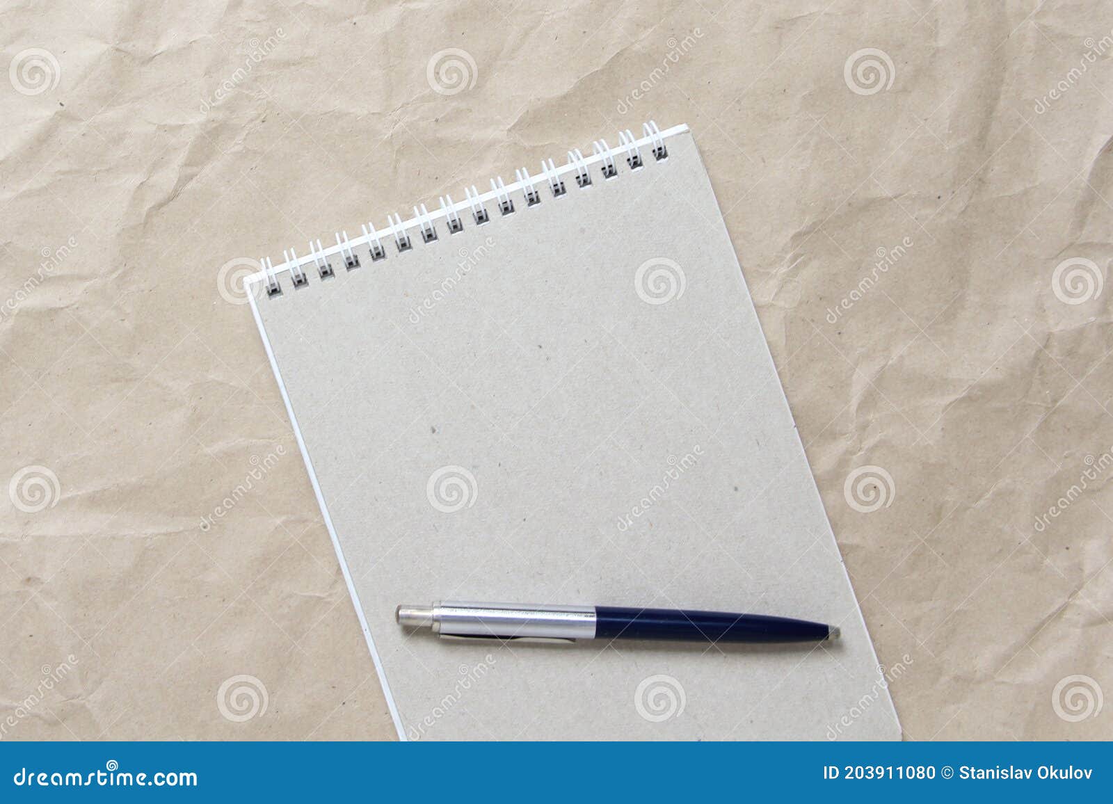 Gray Notepad with White Coiled Spring and Pen on a Background of Beige ...