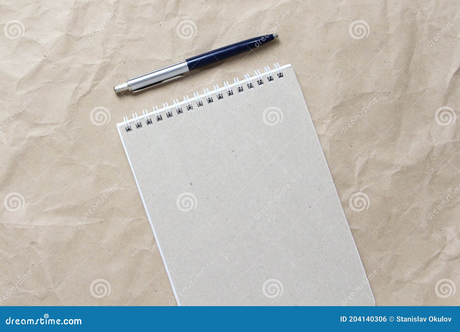 Gray Notepad with White Coiled Spring and Pen on a Background of Beige ...