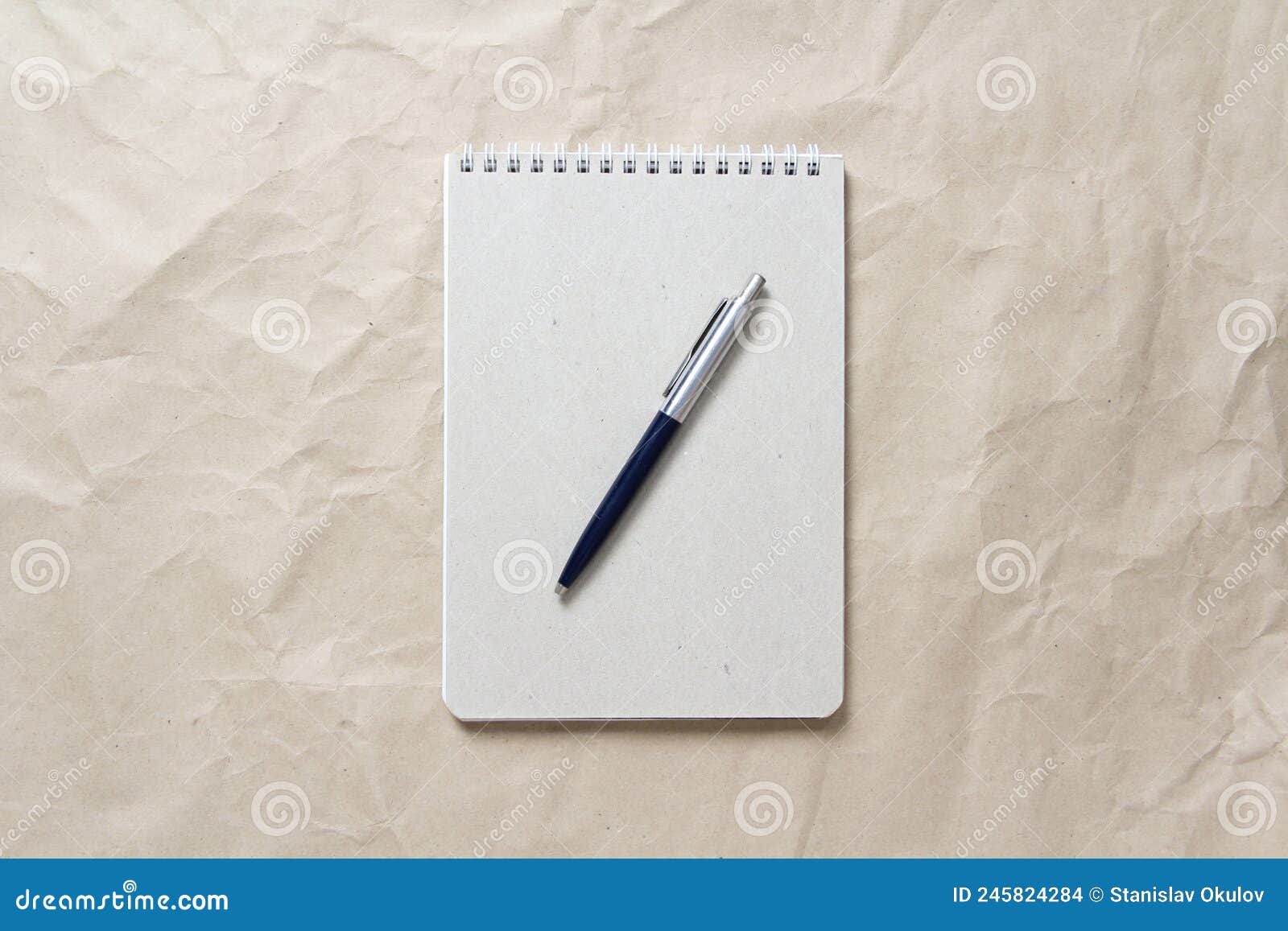Gray Notepad with White Coiled Spring and Pen on a Background of Beige ...
