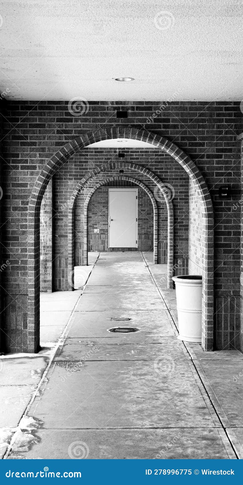 Grayscale of a Brick Building with Arcade Corridor Stock Image - Image ...