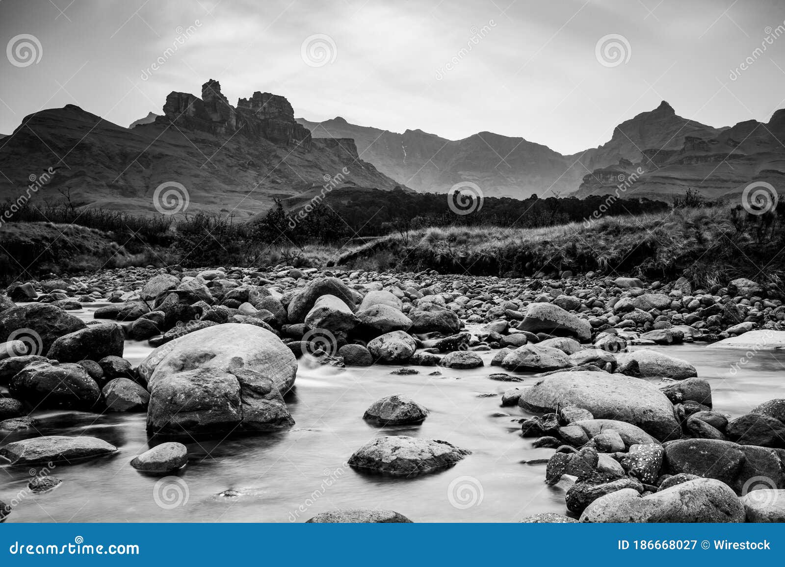 Grayscale Shot of a River with Tall Mountains in the Background Stock ...