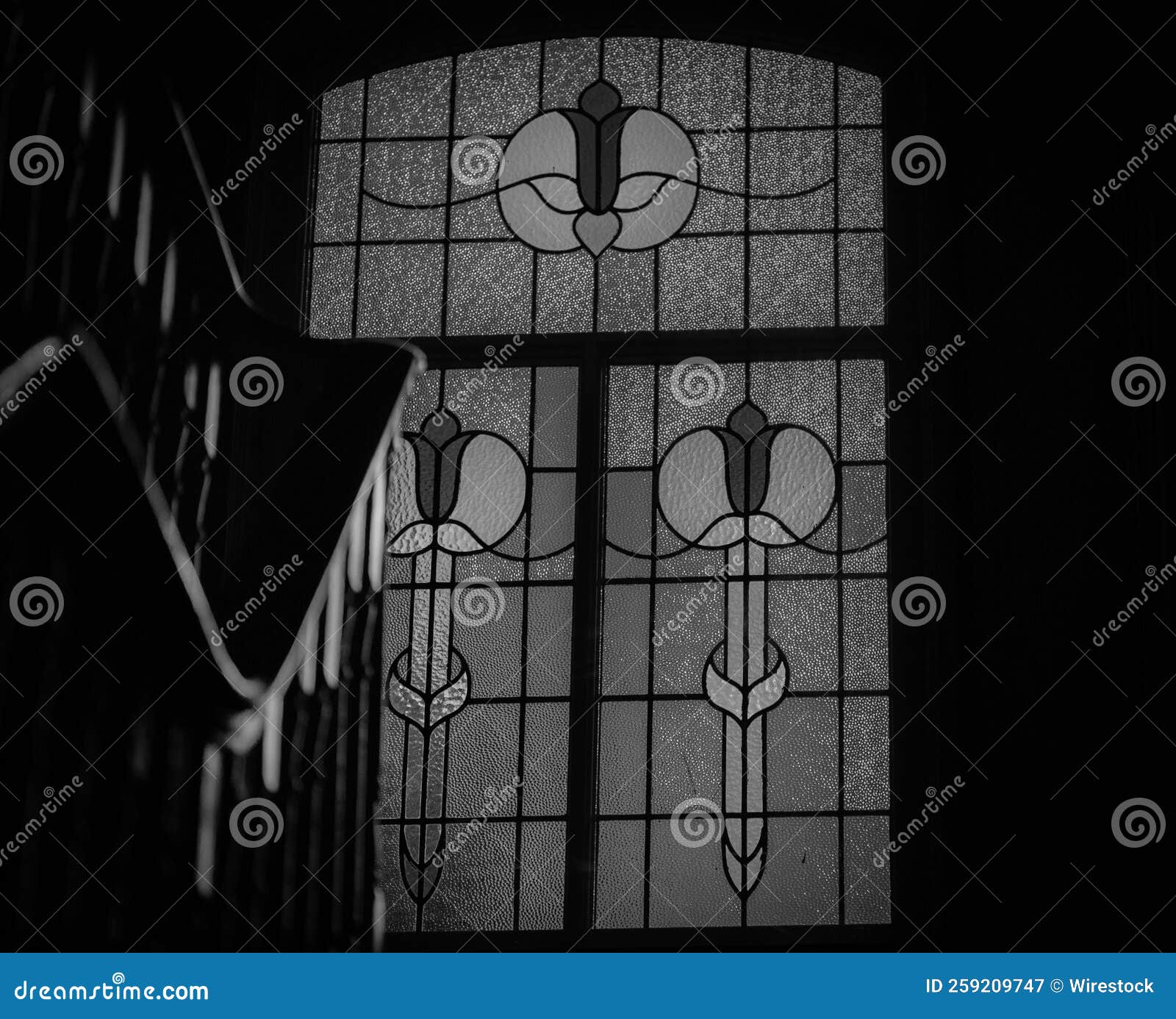 Grayscale Shot of a Stained Glass Window at Night with Stairs Railing ...