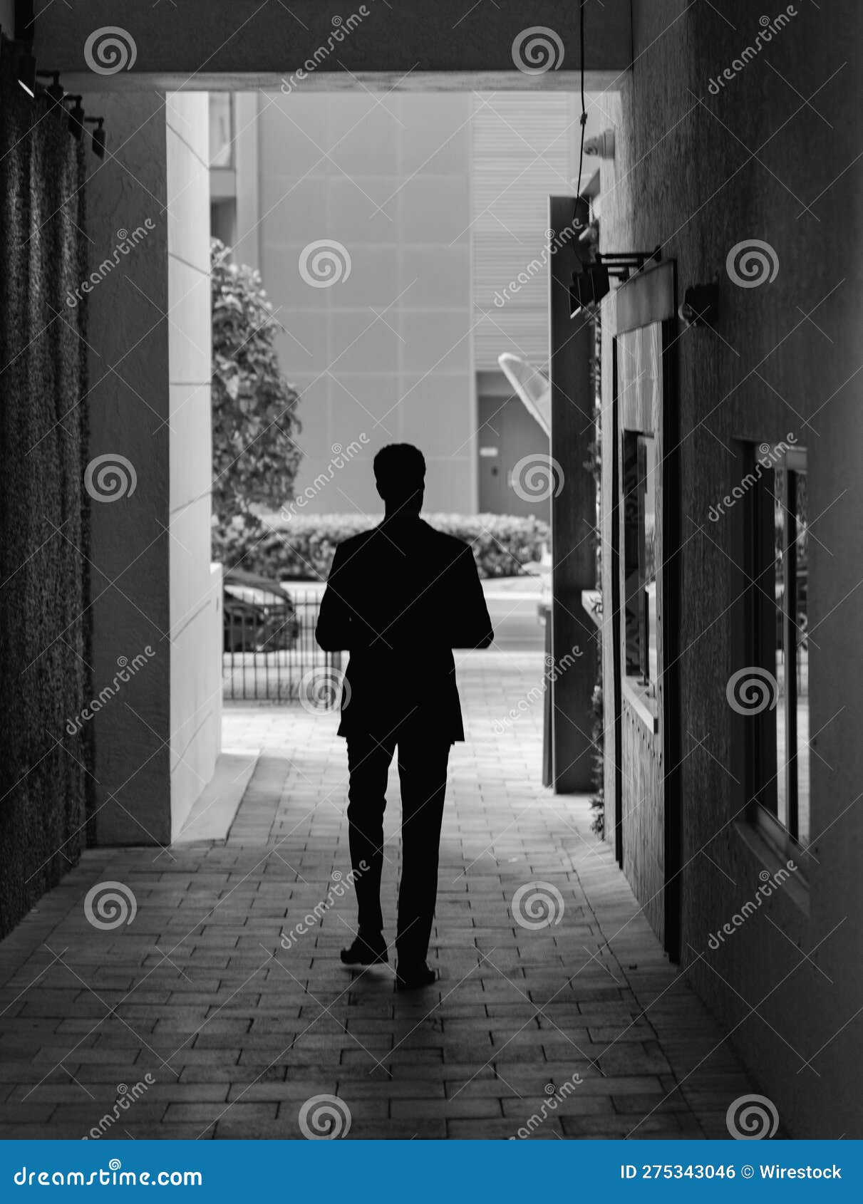 Grayscale of a Silhouette of a Man Walking Down a Long and Empty ...