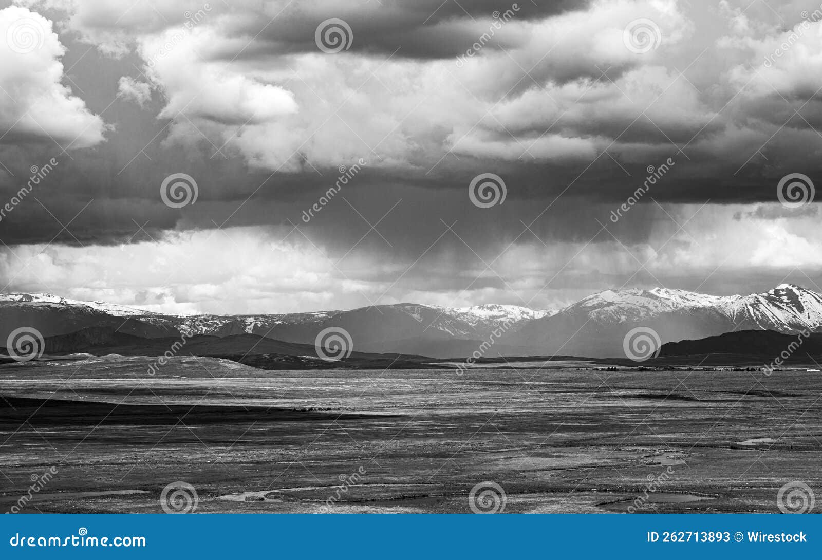 Grayscale View of a Valley with Snowy Mountains in the Background Stock ...