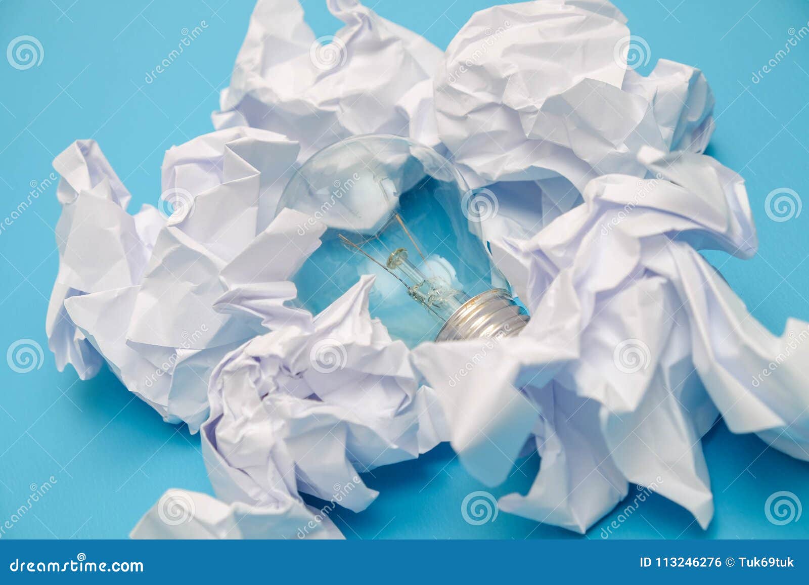 Great Concept with Crumpled Office Paper and Light Bulb on a Blue ...
