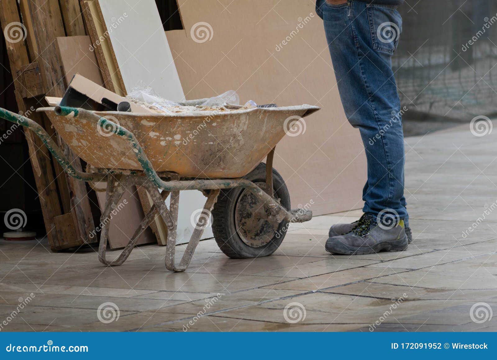Great Shot of a Man Standing in Front of an Old Rusty Wheelbarrow Full ...
